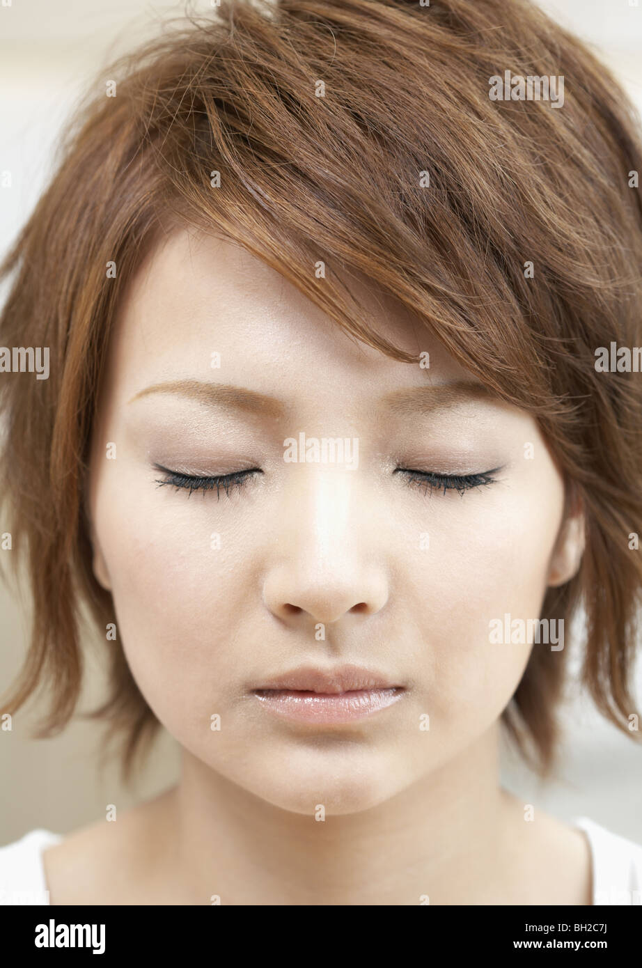 A young woman closing her eyes Stock Photo - Alamy