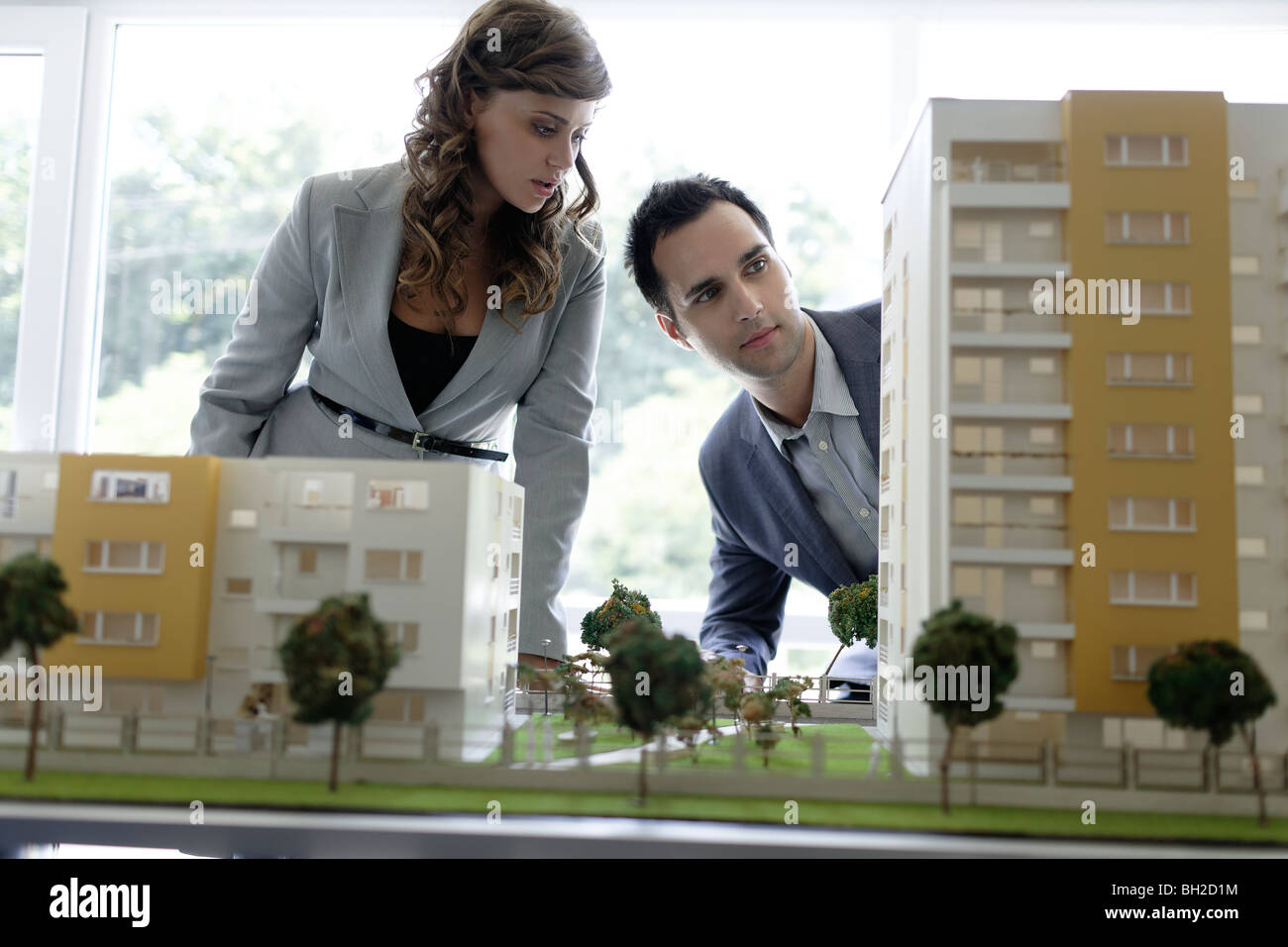 man and woman looking at small architectural building model Stock Photo ...