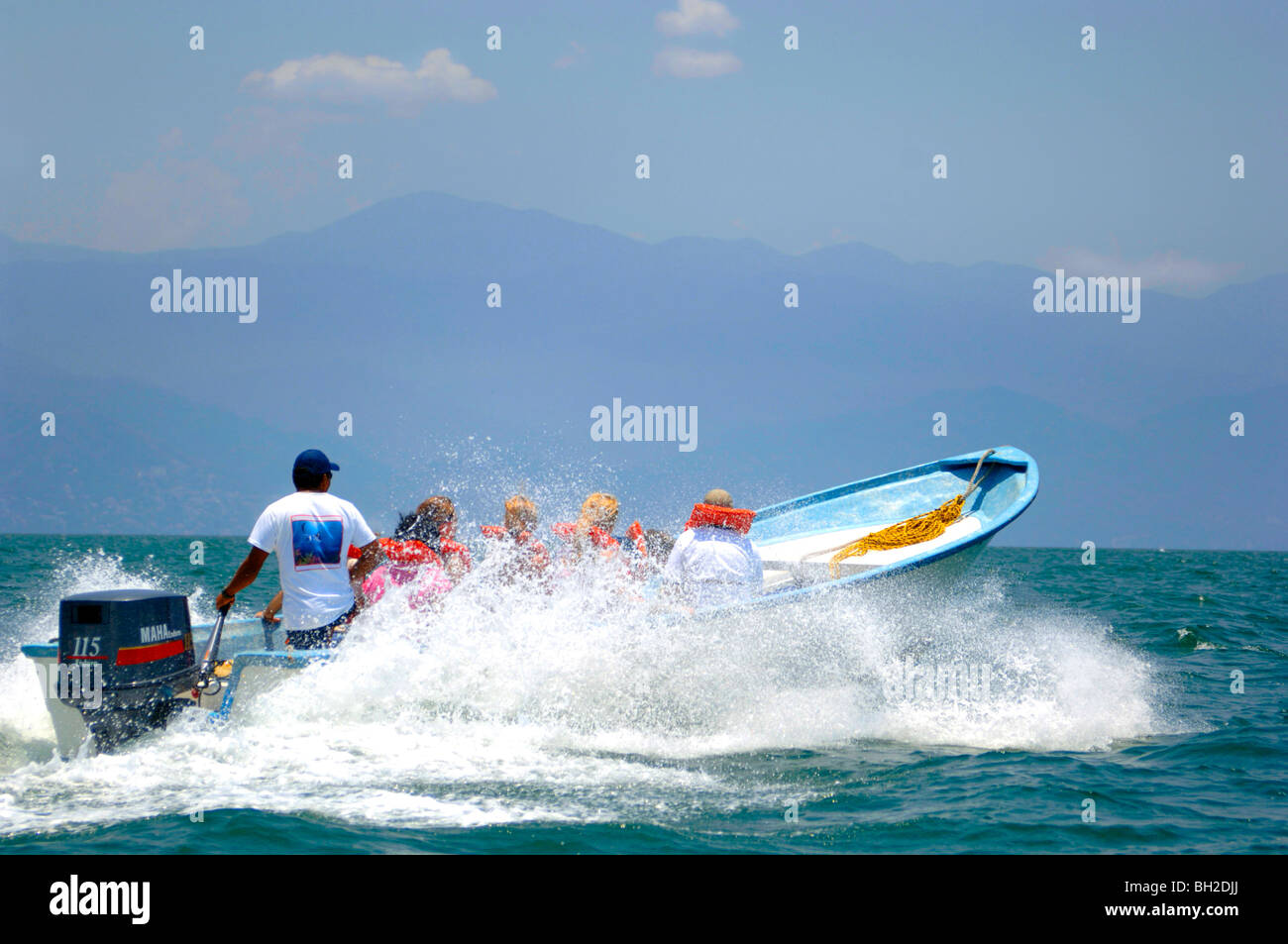 Small john boat loaded with tourist races on the Pacific ocean as it ...