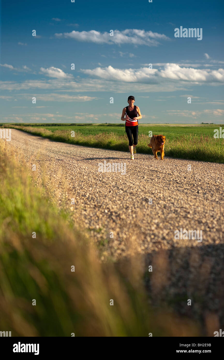 Female runner and dog, on rural road, Saskatchewan Stock Photo - Alamy