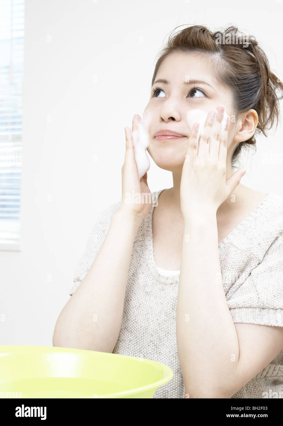 A young woman washing her face Stock Photo - Alamy