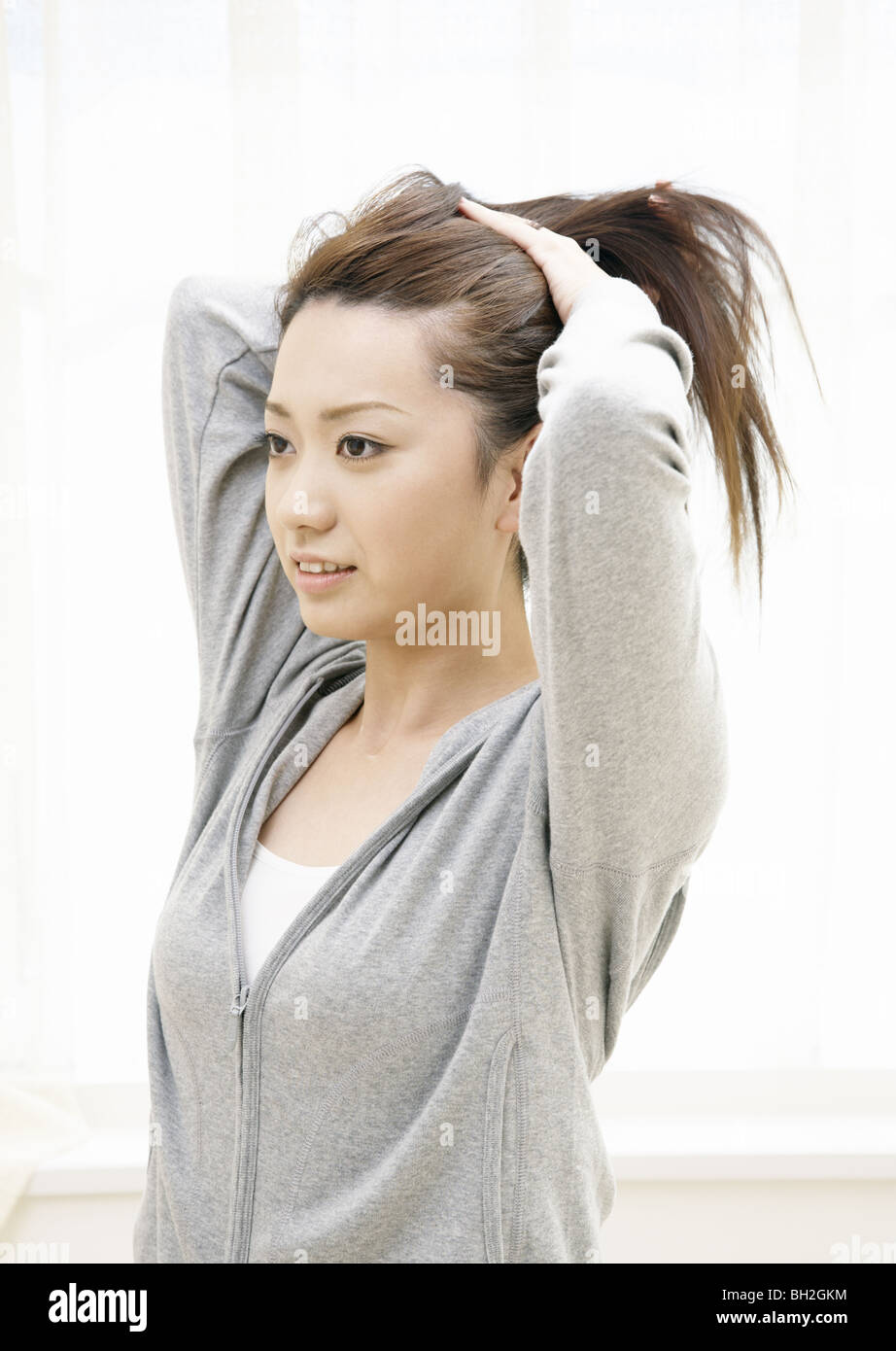 A young woman fixing her hair Stock Photo - Alamy