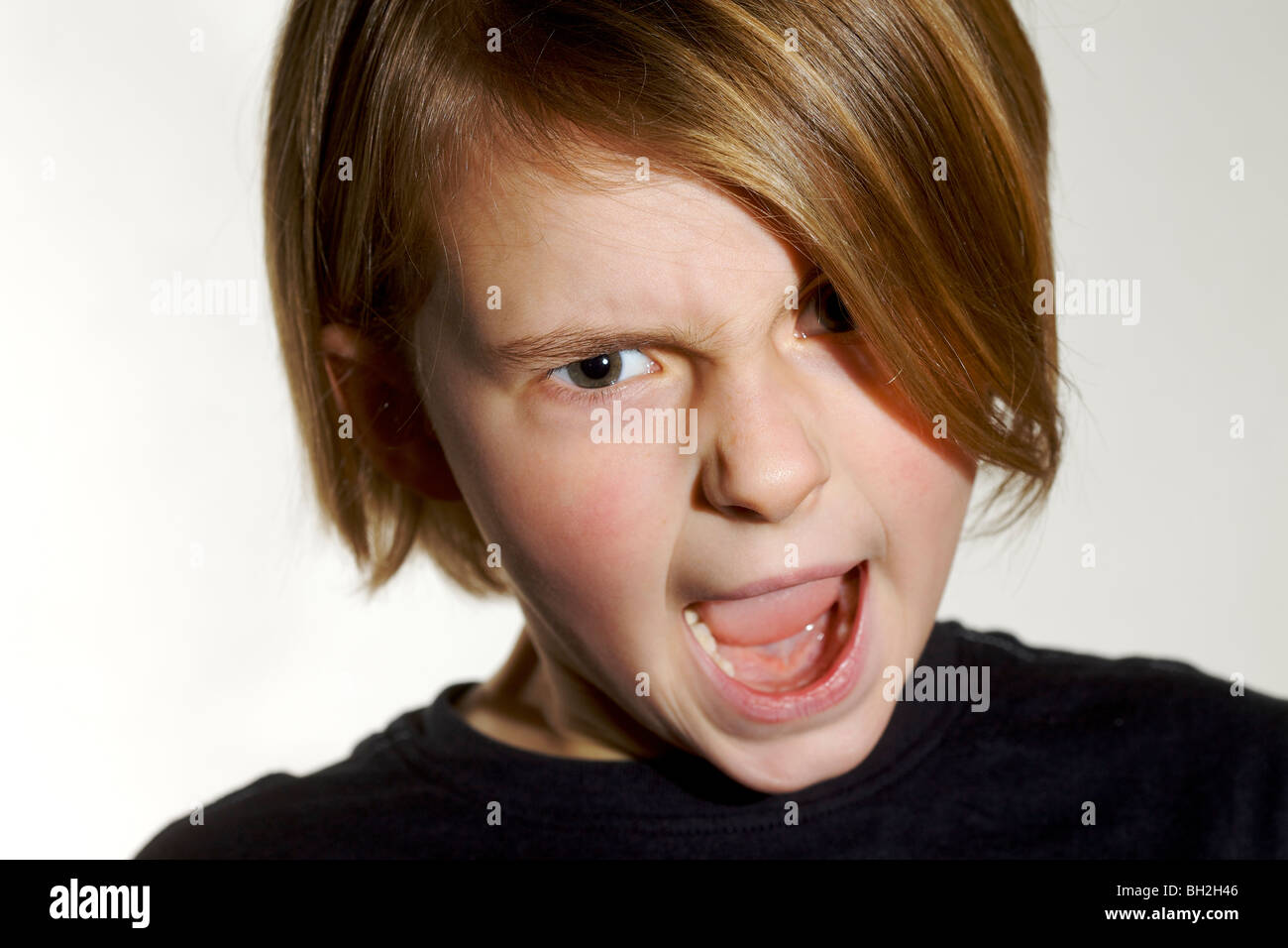 Young blonde girl shouting screaming angry alarmed surprised hostile ...