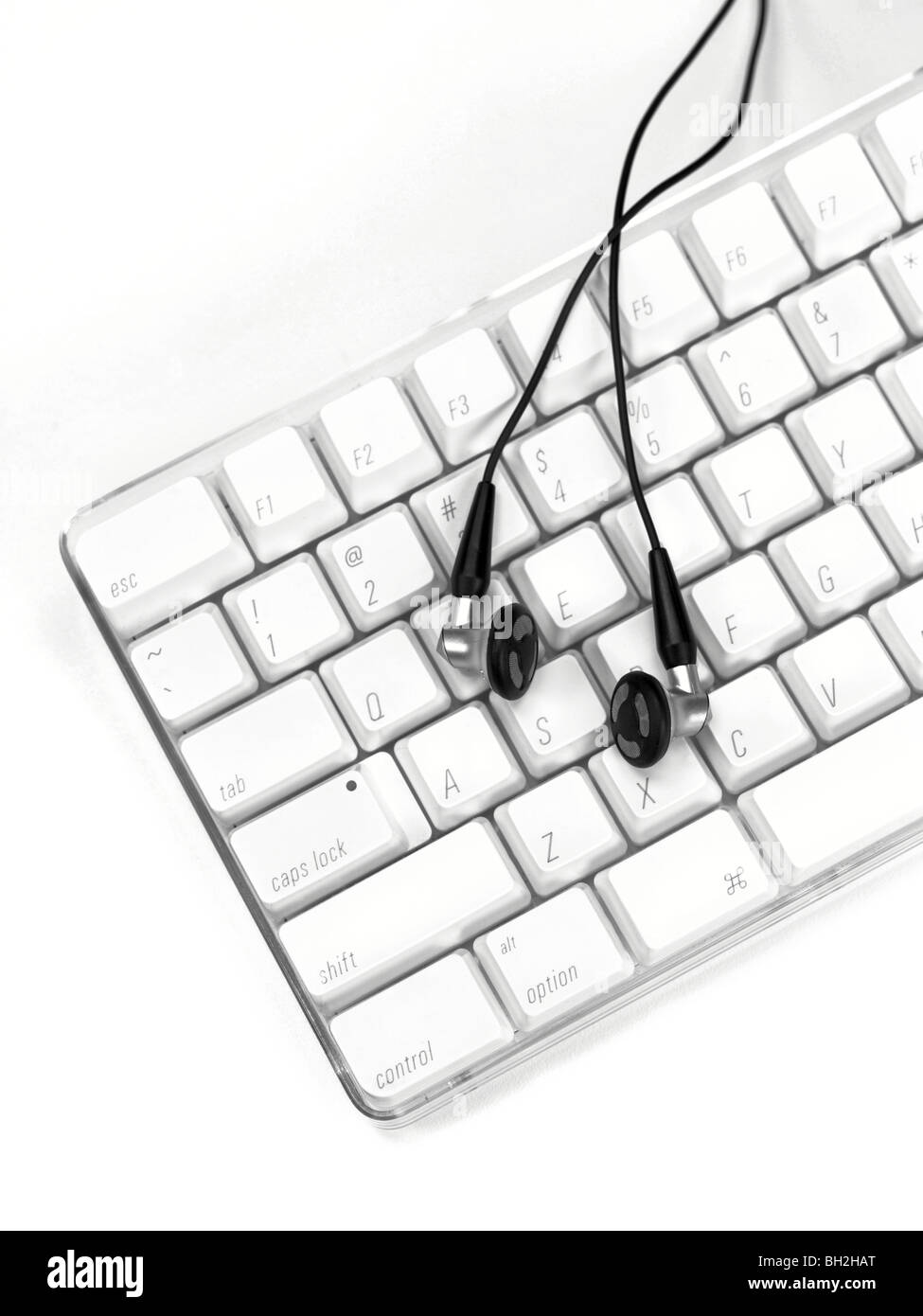 A laptop computer with a set of earphones isolated against a white ...