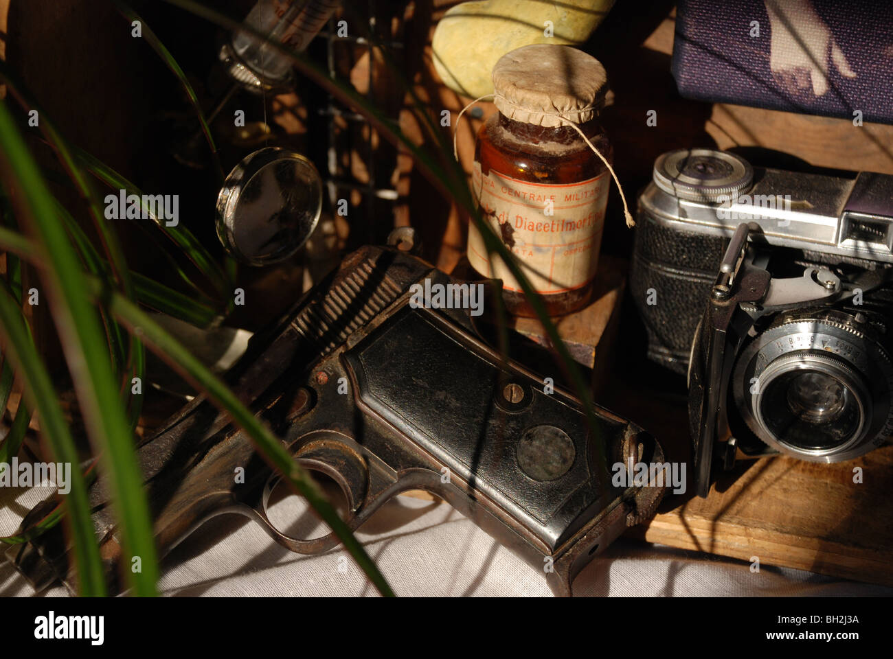 still life of a vintage camera, gun and vintage pharmaceutical bottle ...