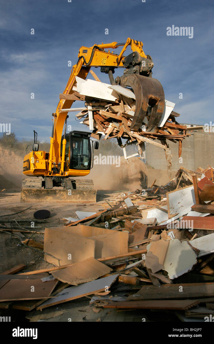 A JCB digger loading recycled wood into a chipper Stock Photo - Alamy