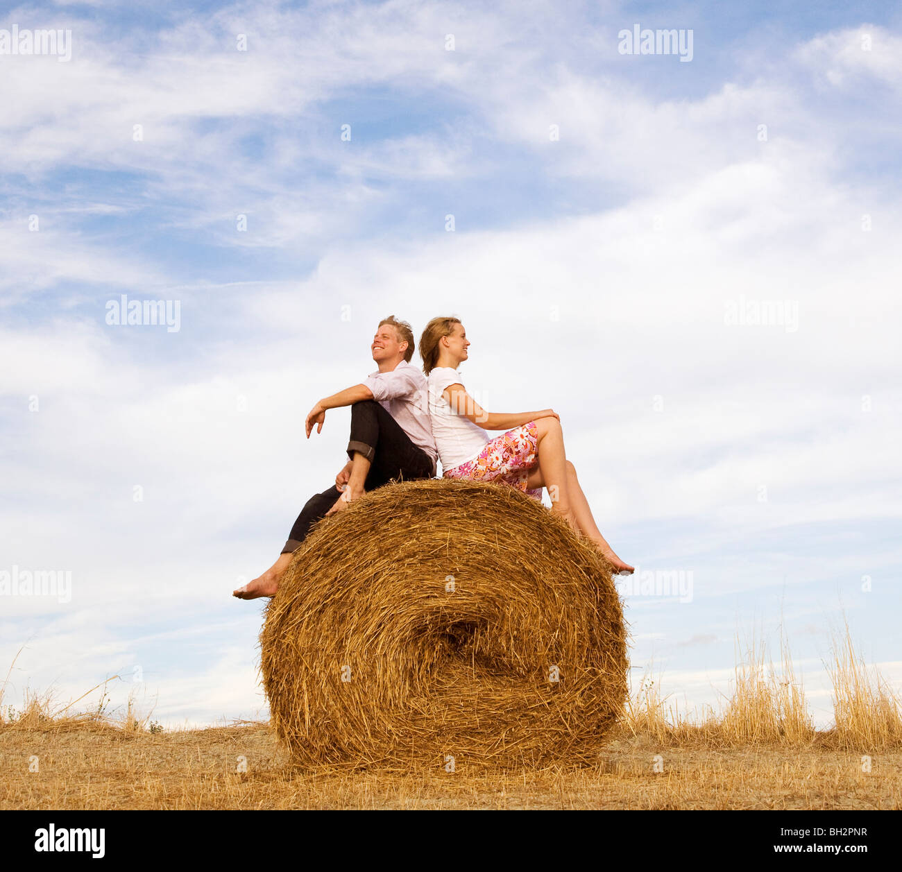 woman and man sitting on hay bale Stock Photo - Alamy