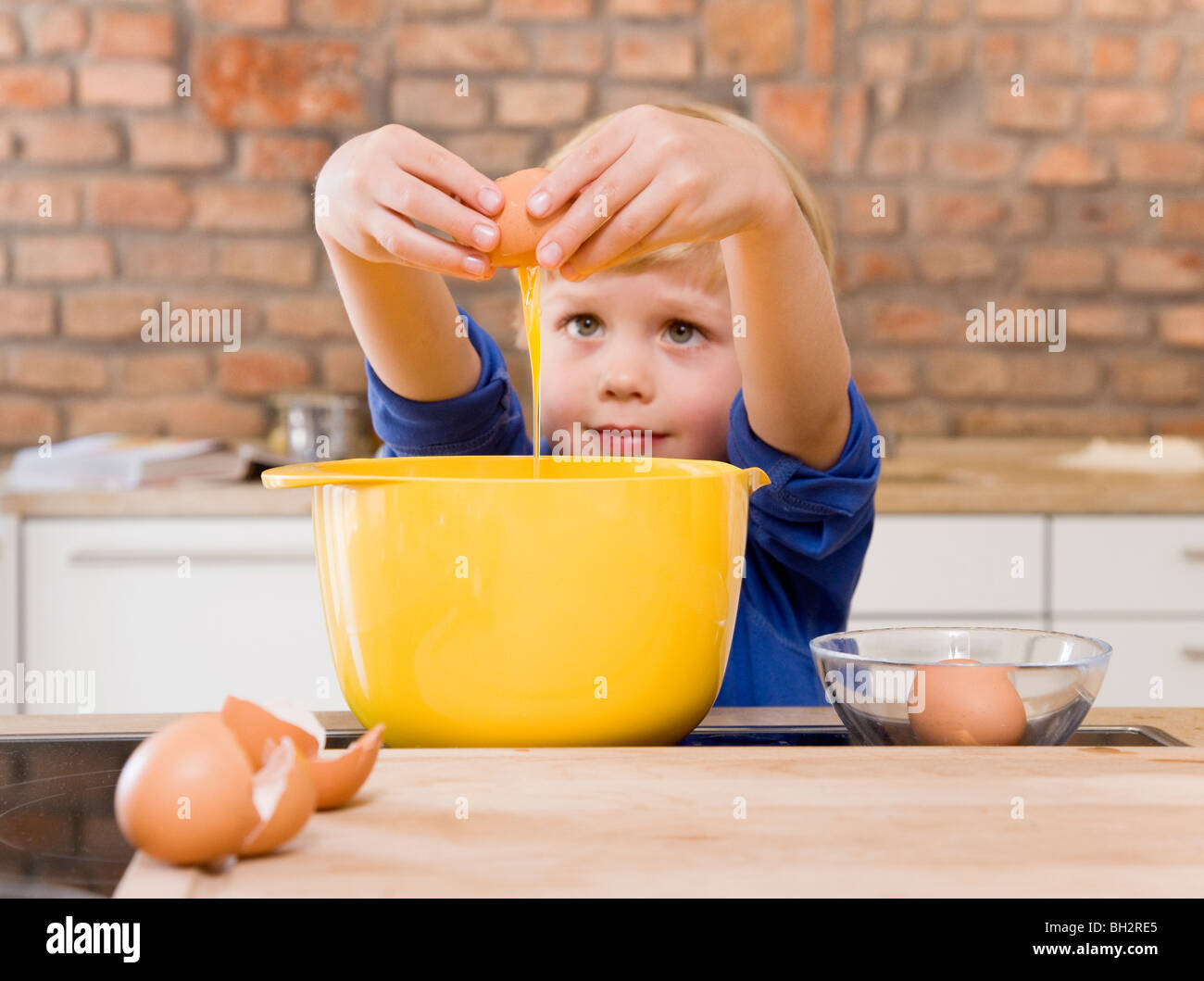 boy adding eggs to bowl Stock Photo - Alamy