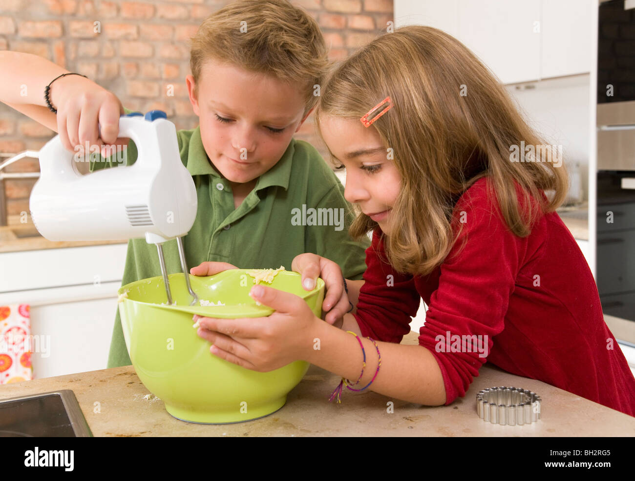 girl and boy stirring dough Stock Photo - Alamy