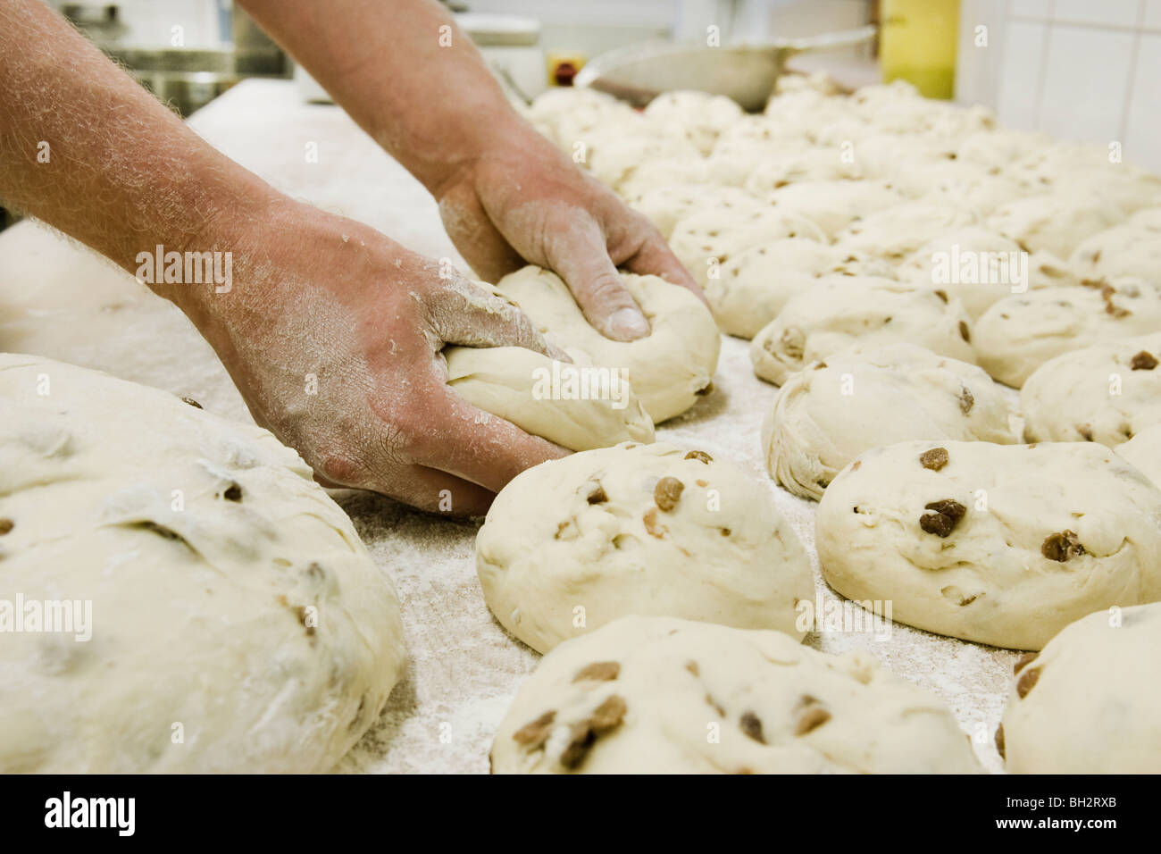 Two hands working on rolls in a bakery Stock Photo - Alamy