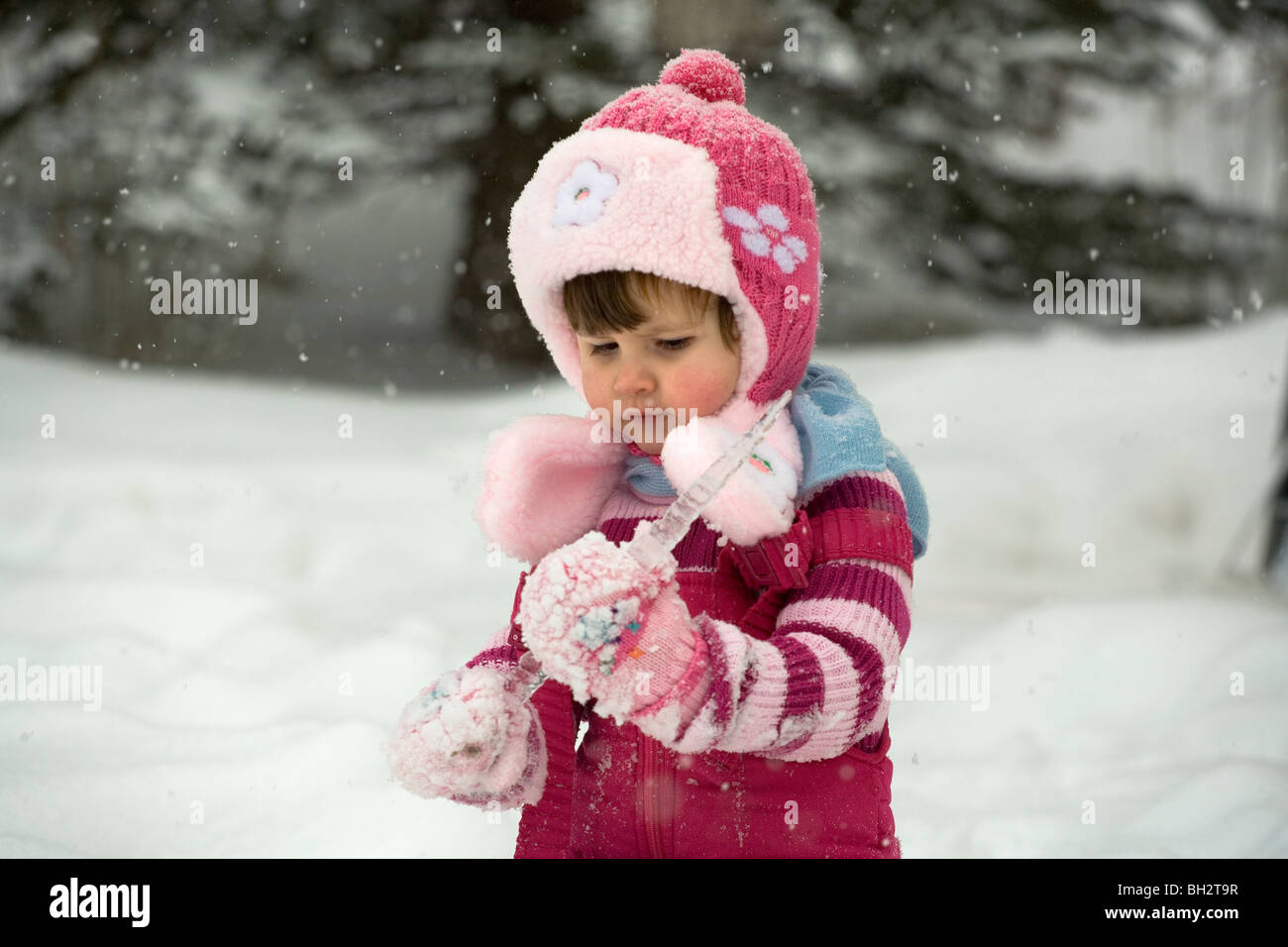 Cute little girl eating an icicle Stock Photo - Alamy