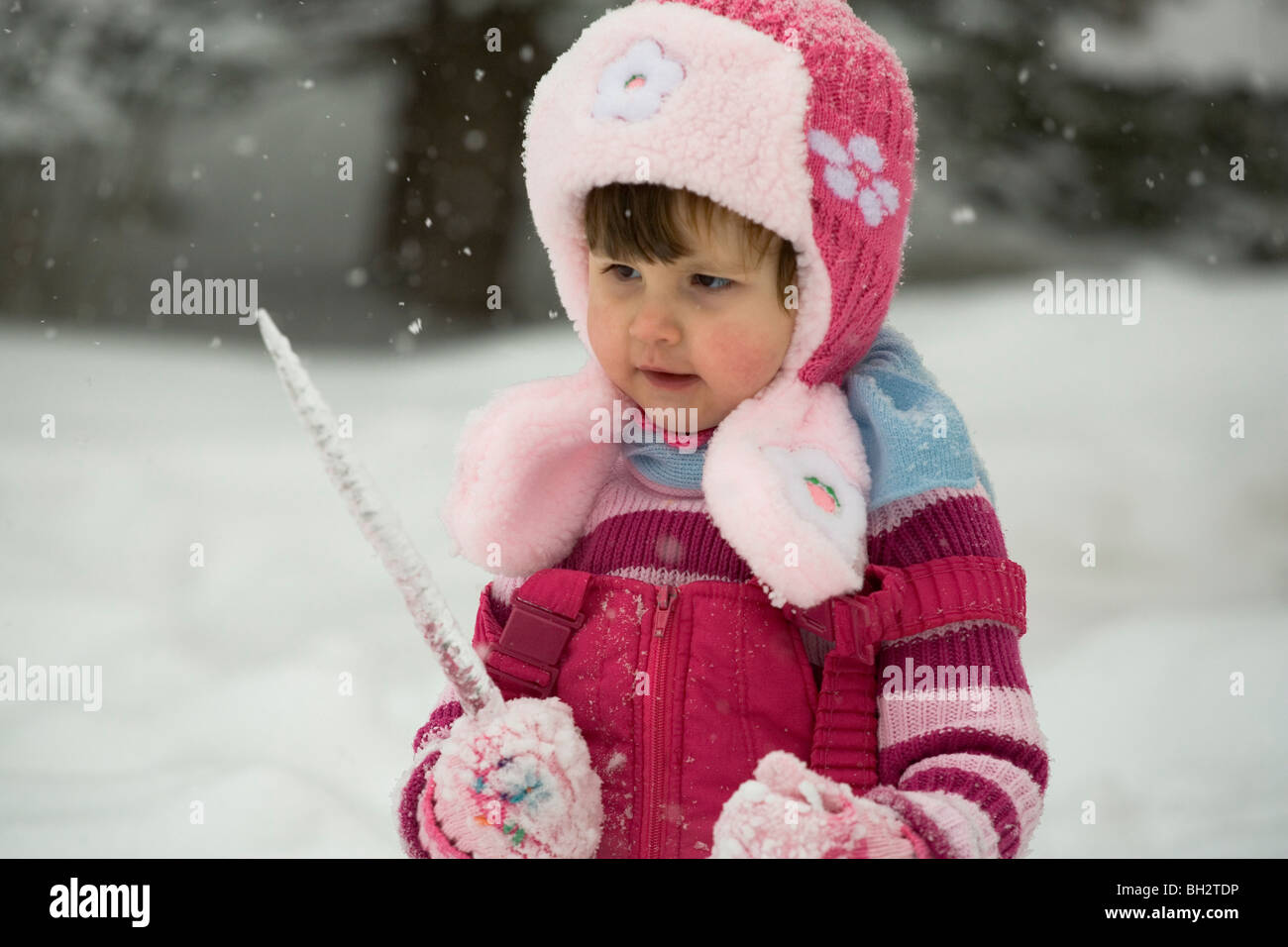 Cute little girl eating an icicle Stock Photo - Alamy