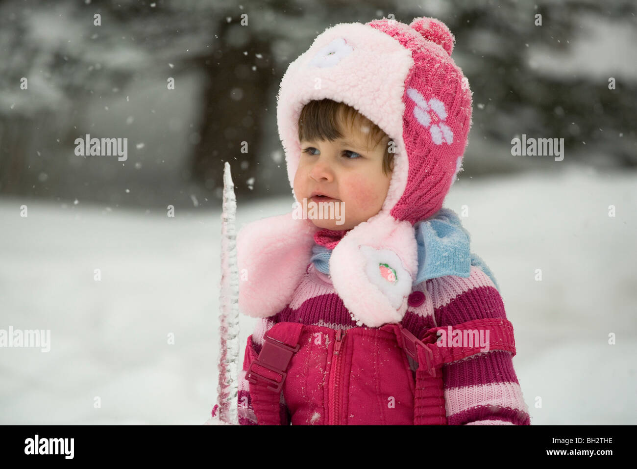 Cute little girl eating an icicle Stock Photo - Alamy
