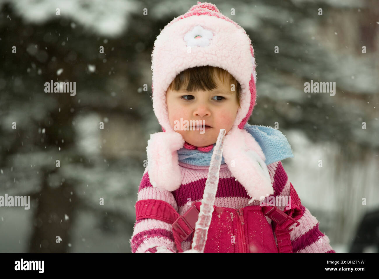 Cute little girl eating an icicle Stock Photo - Alamy