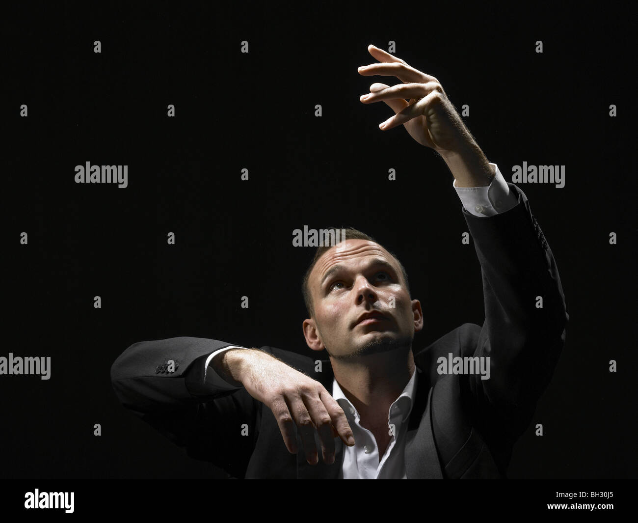 Music Conductor using his hands in an upward gesture Stock Photo - Alamy