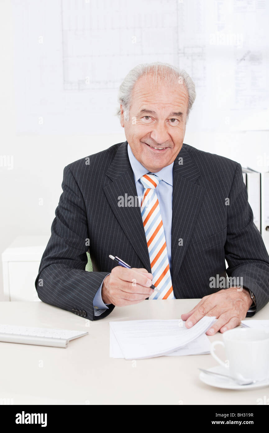 Senior executive signing document Stock Photo - Alamy
