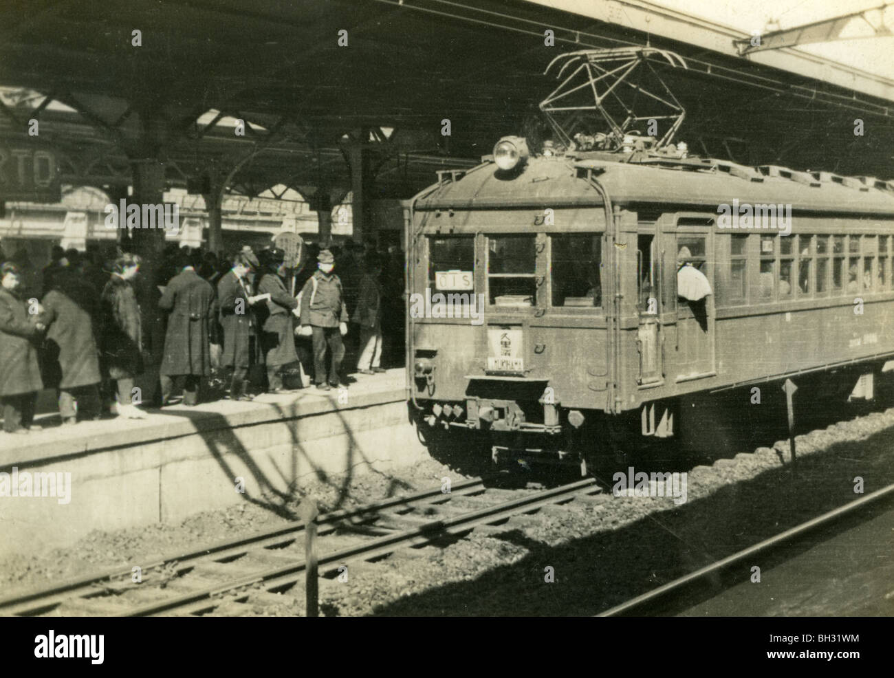 An electric train stops at a rail station in Post World War II Japan ...
