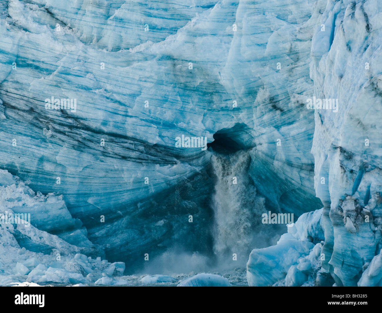 A moulin waterfall pours from the face of a glacier in Alaska Stock ...