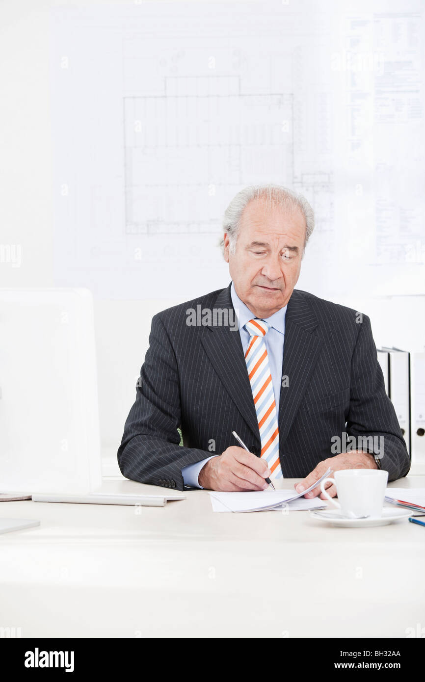 Senior businessman signing document Stock Photo - Alamy