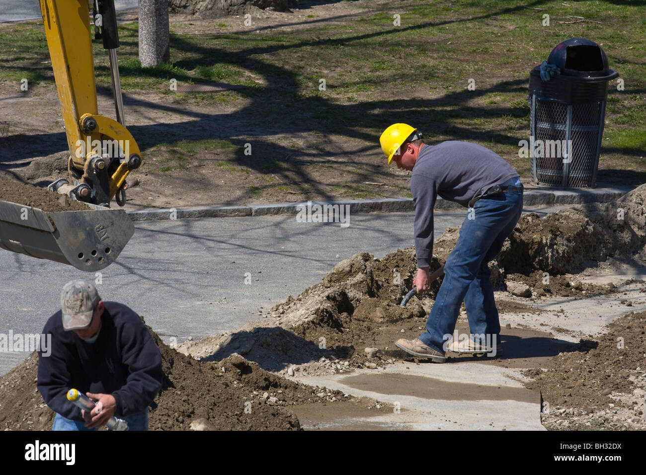 Construction worker with hardhat using a shovel Stock Photo - Alamy