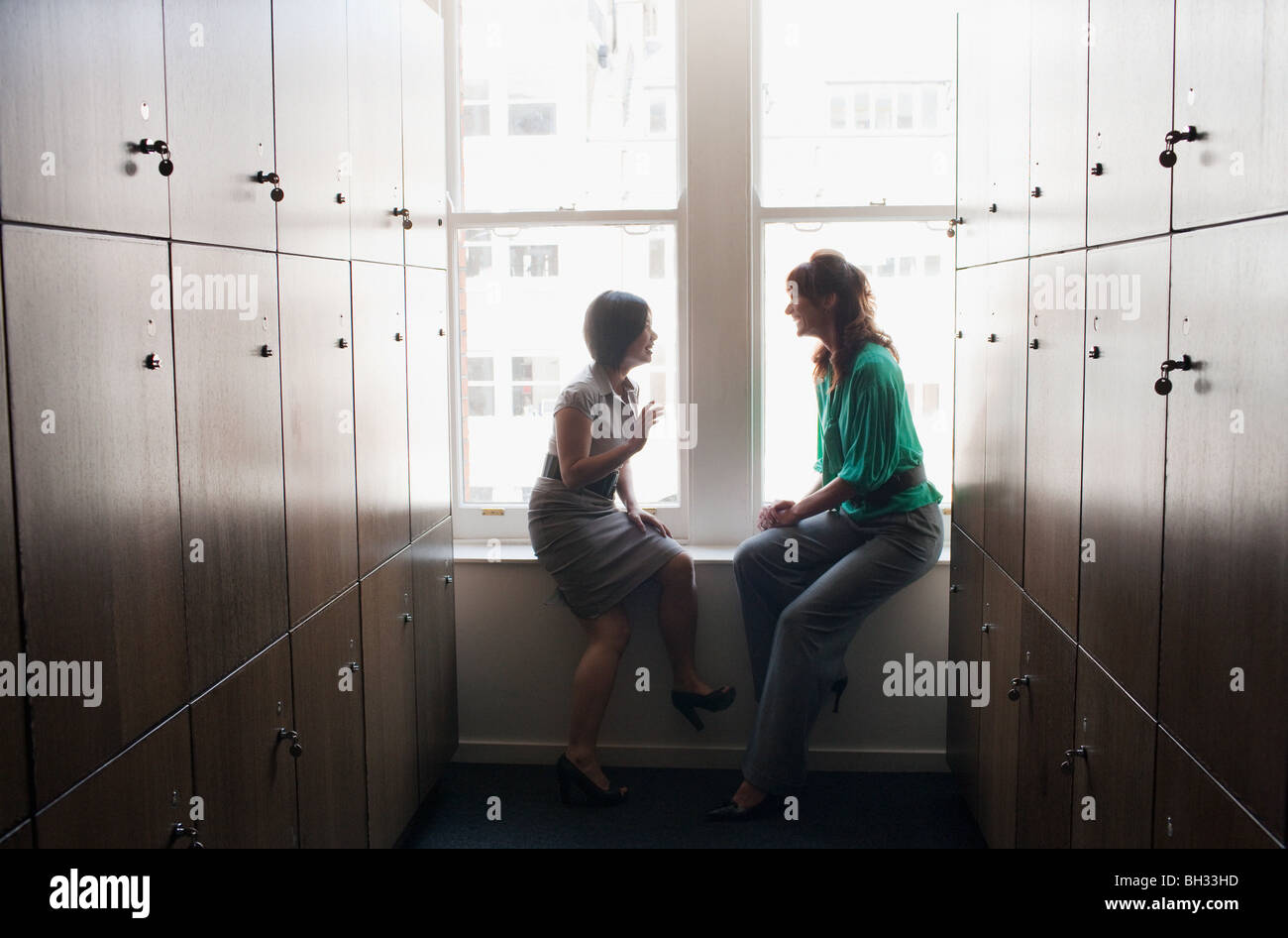 Two business women talking in a locker Stock Photo - Alamy