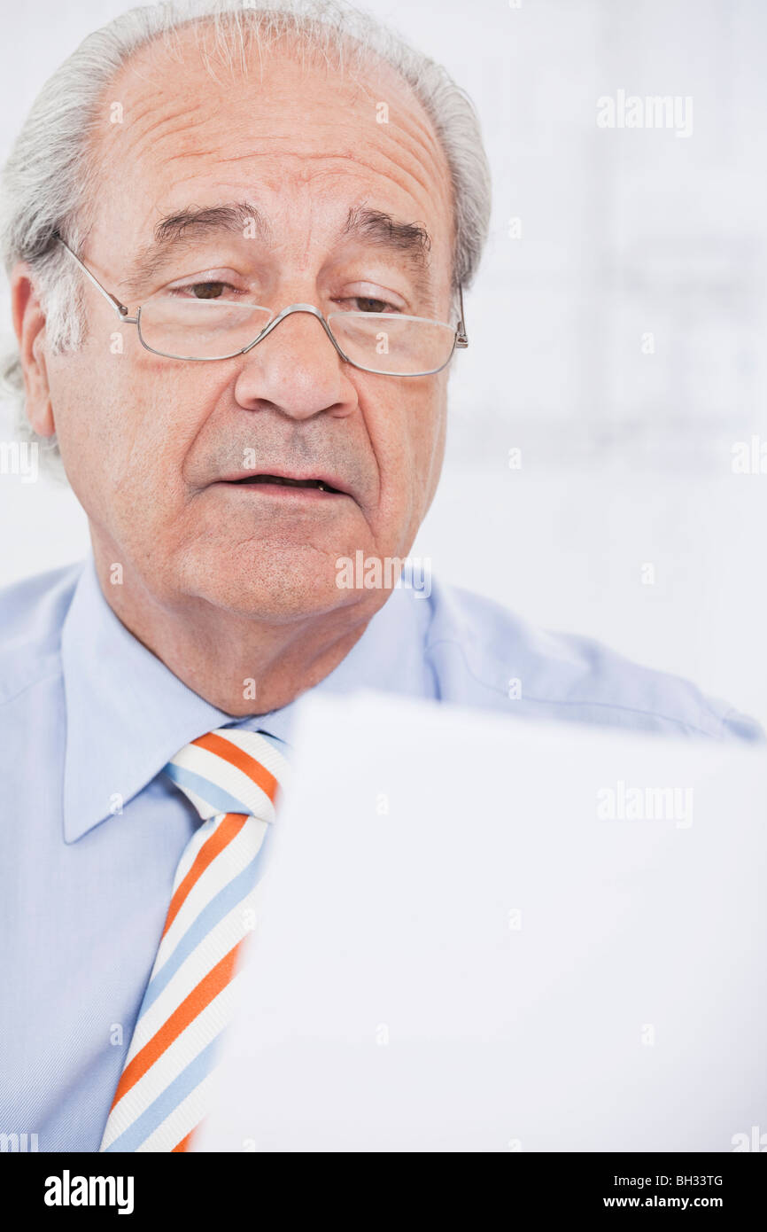 Senior businessman reading a paper Stock Photo - Alamy