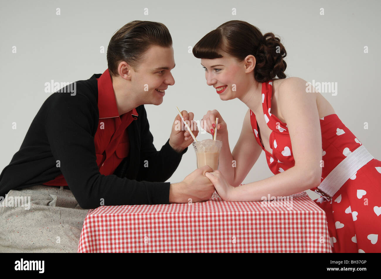 Couple sharing a milkshake in 1950s diner Stock Photo - Alamy