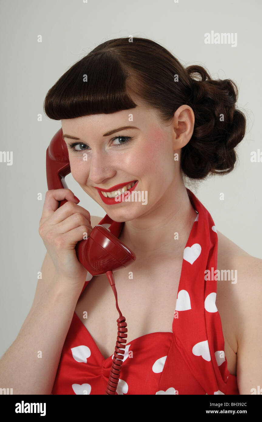 Pretty girl in 1950s dress holding a telephone Stock Photo - Alamy