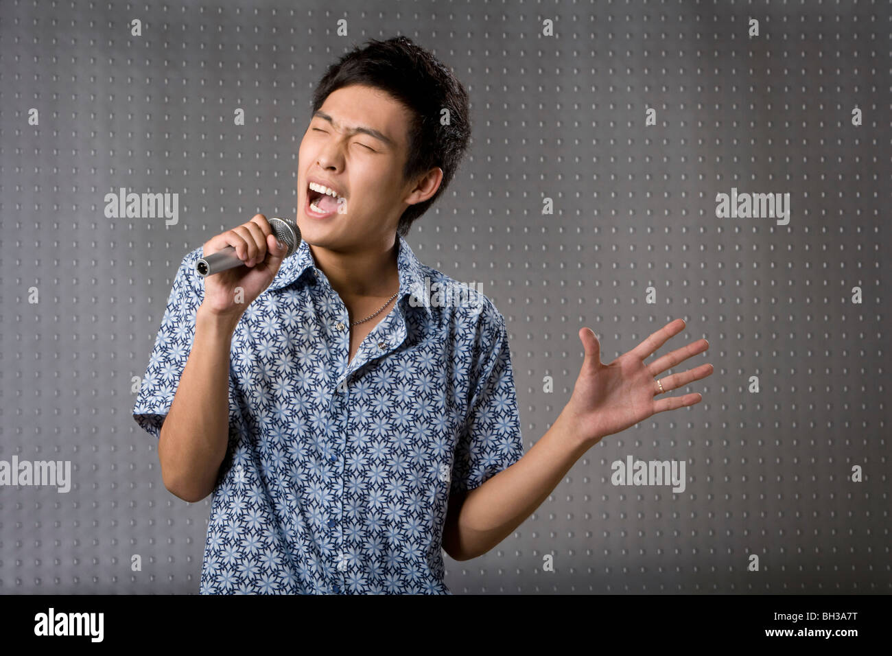 Young man singing karaoke Stock Photo - Alamy