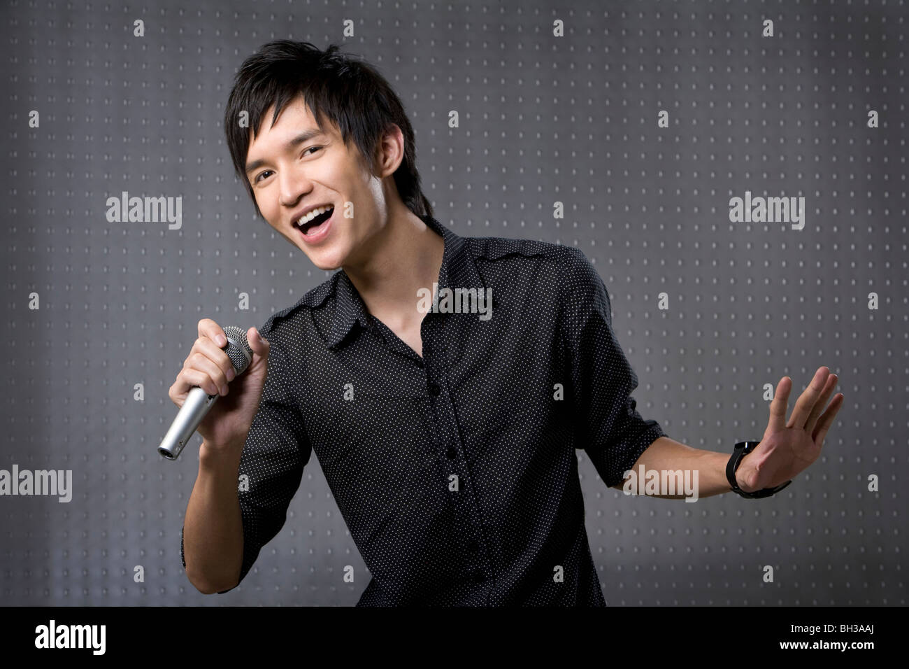Young man singing karaoke Stock Photo - Alamy