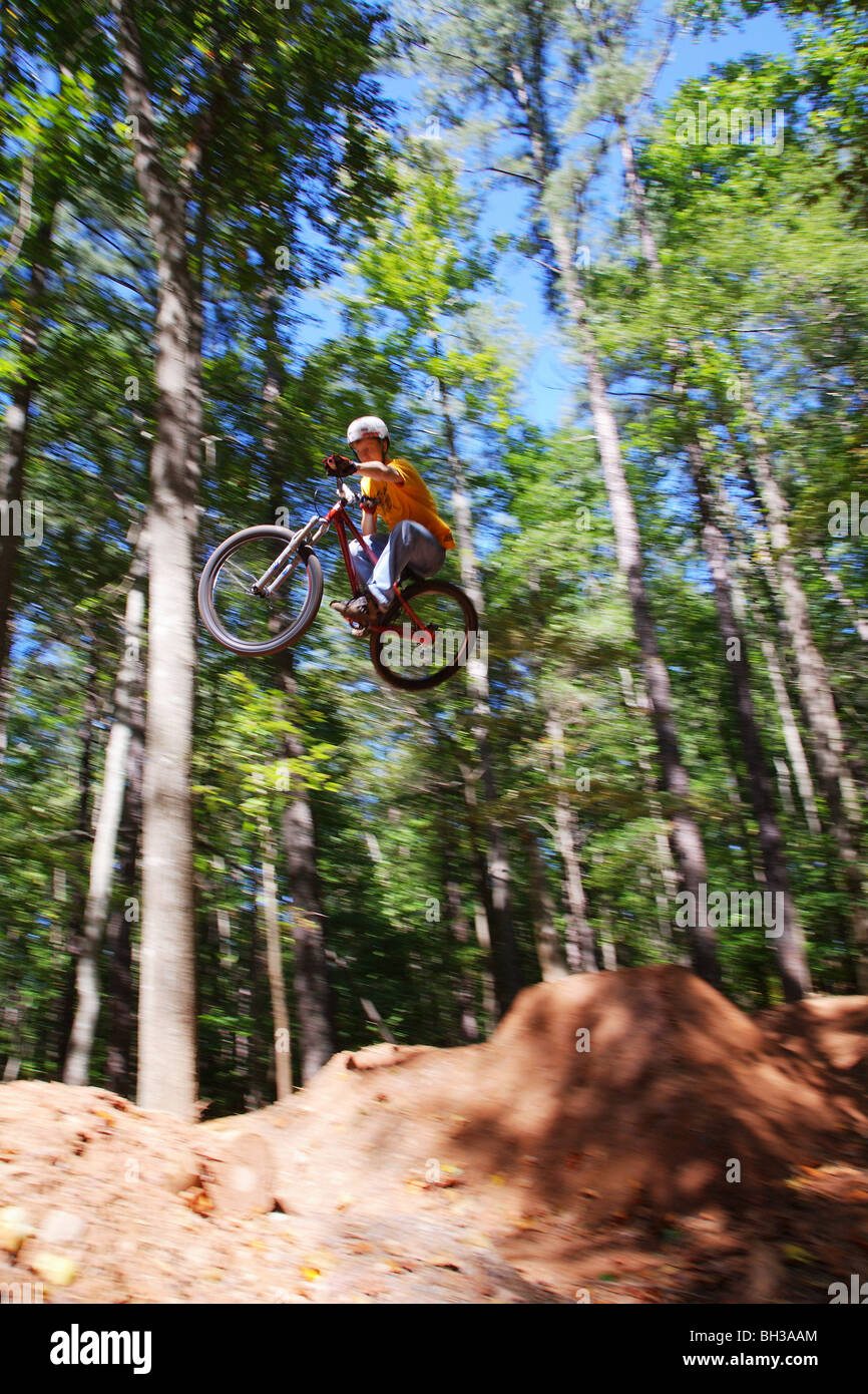 MOUNTAIN BIKER ON BICYCLE LEAPING OVER A JUMP AND PERFORMING A TRICK ...