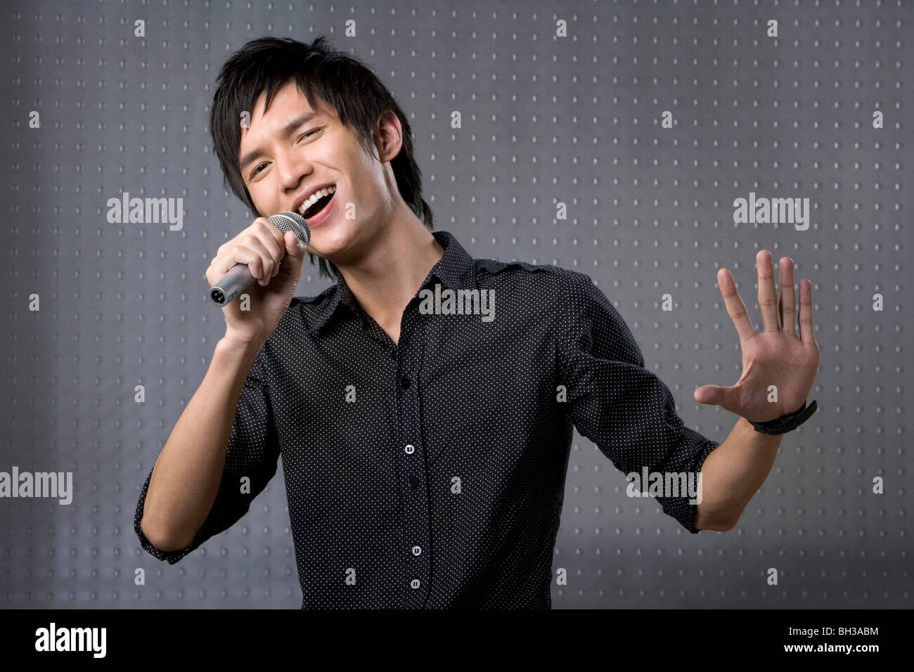 Young man singing karaoke Stock Photo - Alamy