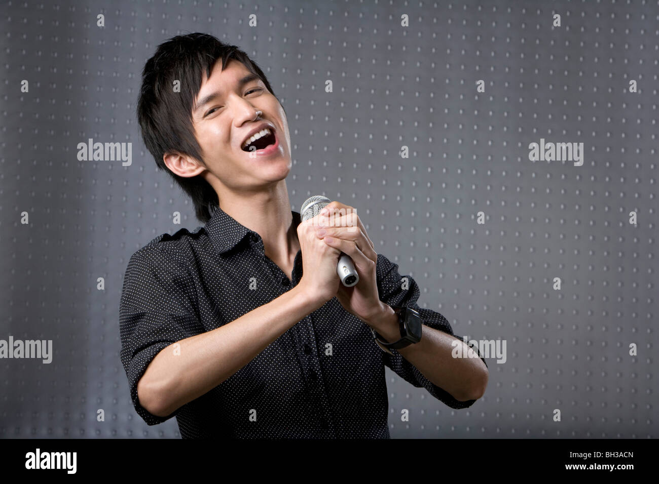 Young man singing karaoke Stock Photo - Alamy