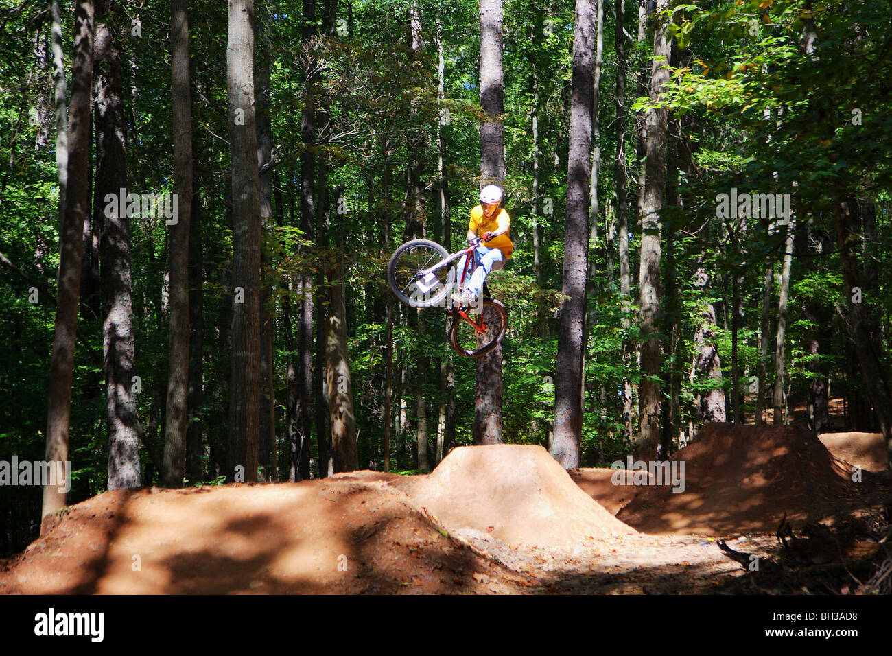 MOUNTAIN BIKER ON BICYCLE LEAPING OVER A JUMP AND PERFORMING A TRICK NO ...