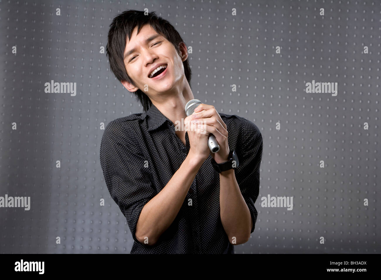 Young man singing karaoke Stock Photo - Alamy
