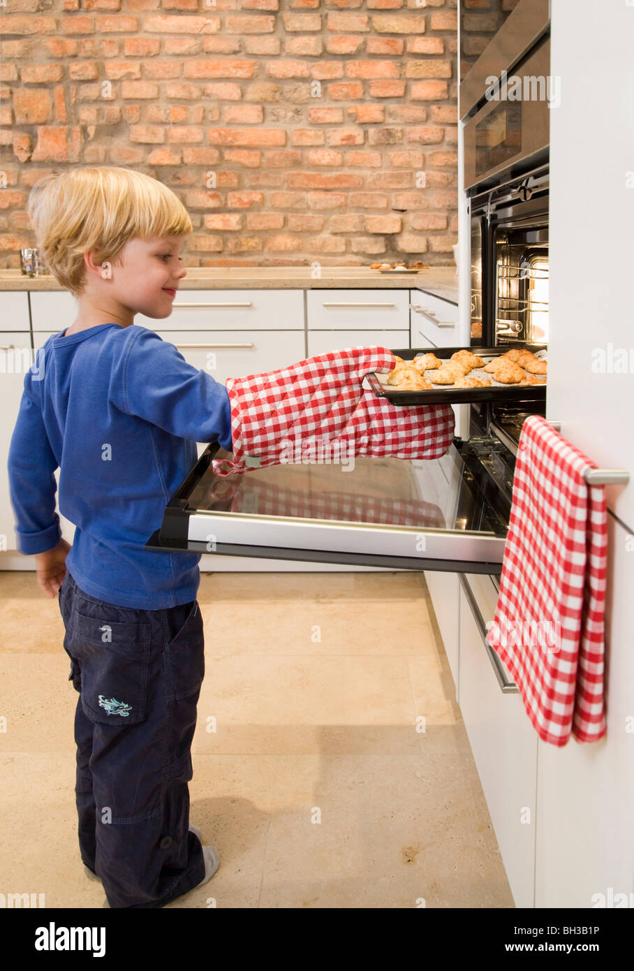 boy taking baked cookies from oven Stock Photo - Alamy