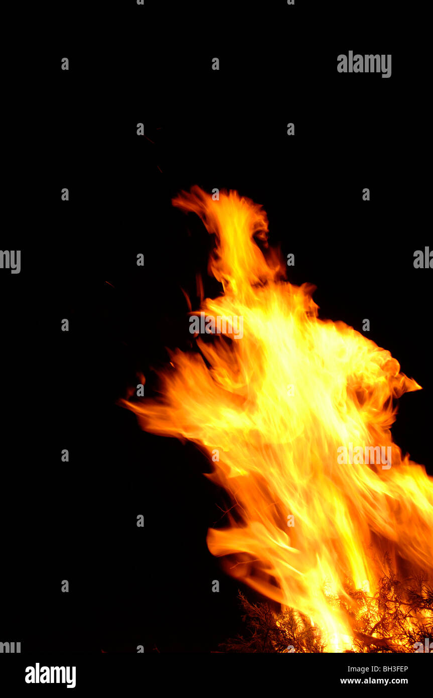 Flames of a outdoor campfire flare up, dance and surge for a ...