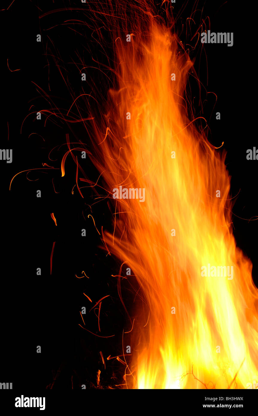 Flames of a outdoor campfire flare up, dance and surge for a ...