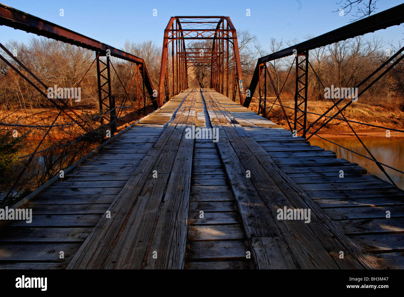Lady meandering along an old dilapidated antique bridge from yesteryear ...