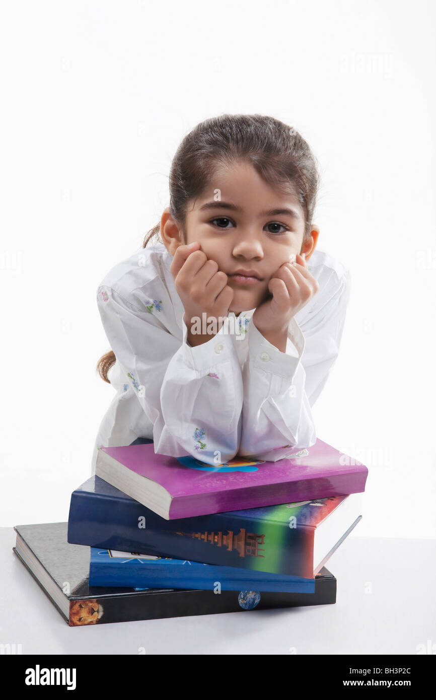 Girl leaning on a stack of books Stock Photo - Alamy