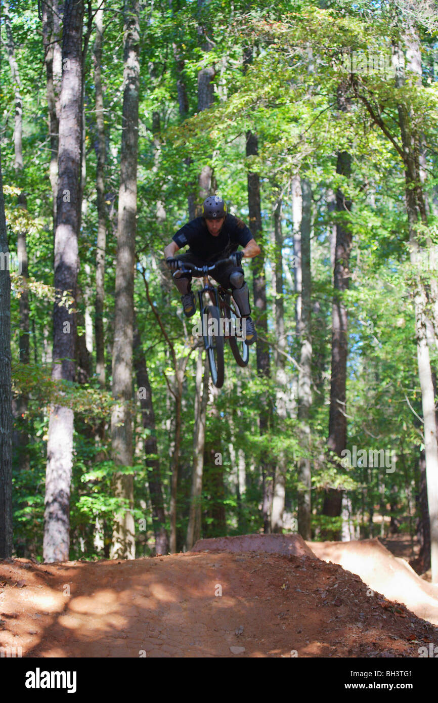 MOUNTAIN BIKER ON BICYCLE LEAPING OVER A JUMP AND PERFORMING A TRICK NO ...