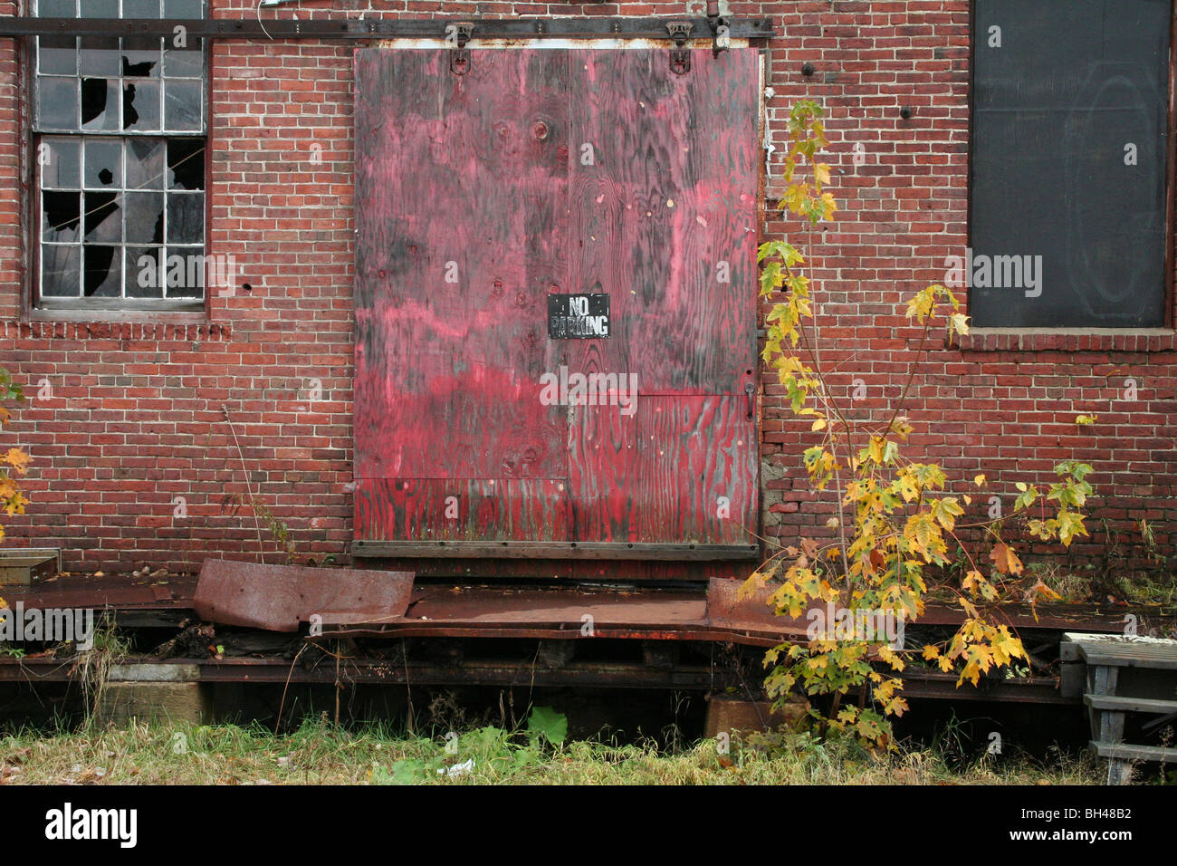 Frontage of a desolate building with broken windows and old door with ...