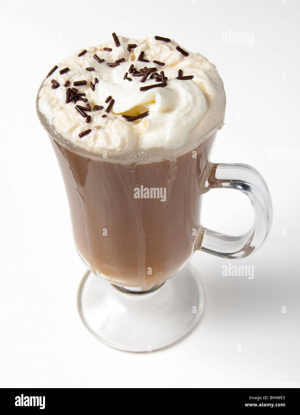 A coffee drink topped with whip cream and chocolate sprinkles on a ...