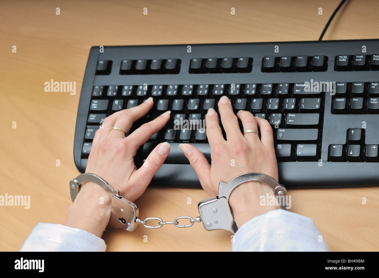 Hands tied with handcuffs typing on keyboard - crime or workaholic ...