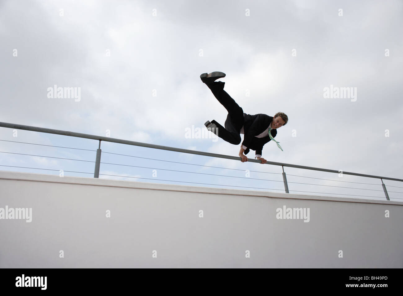 Young businessman leaping over a wall in the city Stock Photo - Alamy