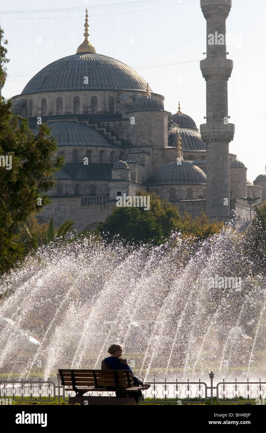 A woman sits on a bench in front of the Sultanahmet Mosque, Istanbul ...