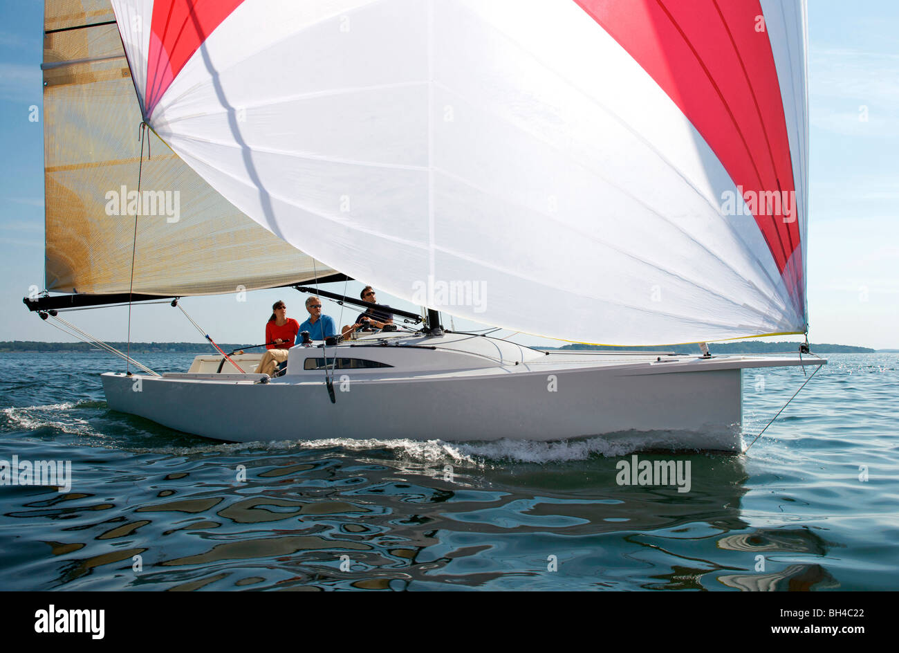 Three adults enjoying a sunny day on board a daysailer on Casco Bay ...