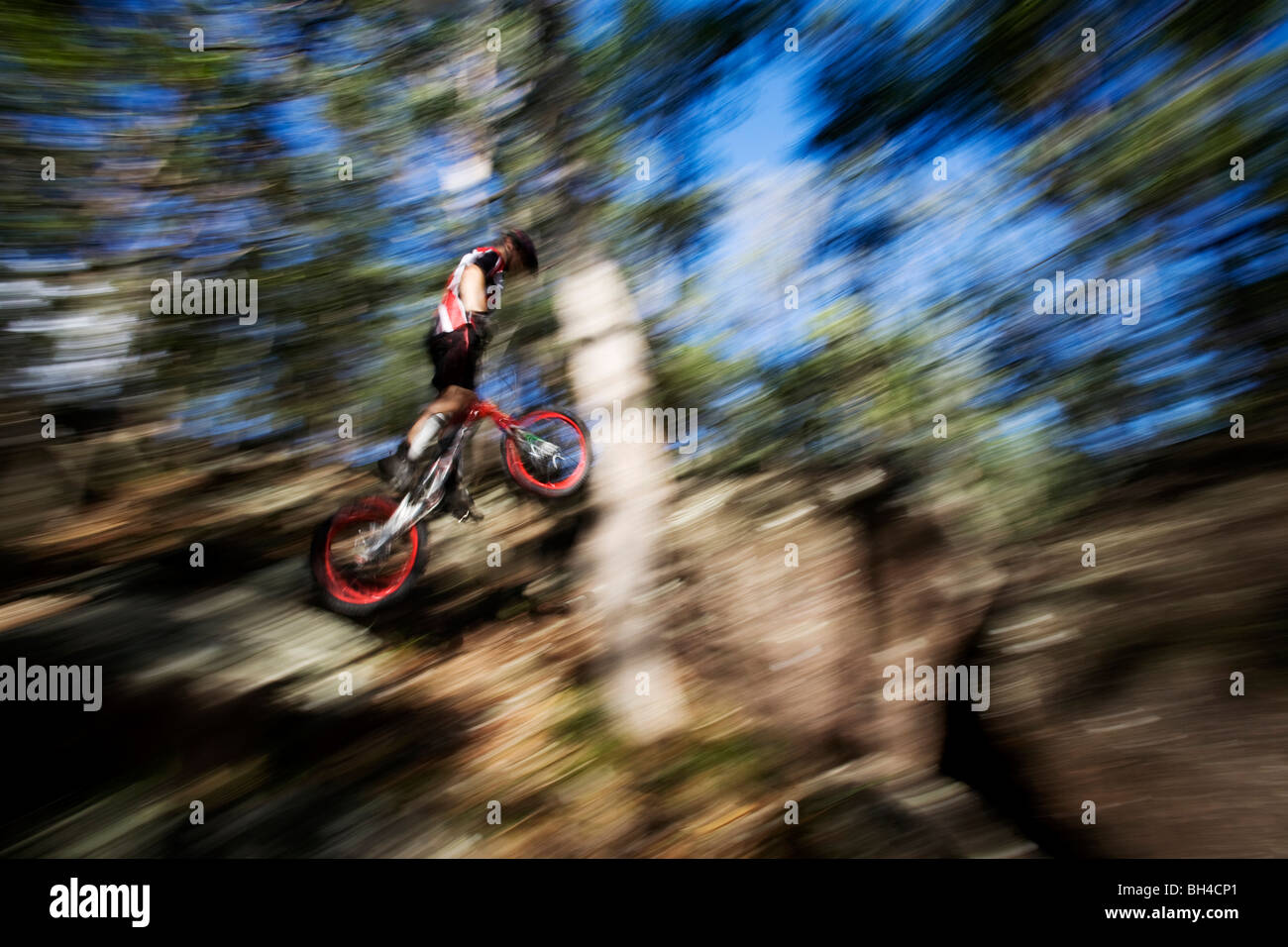 A Trials rider leaps onto a rock at Toohey Forest, Brisbane, Queensland ...