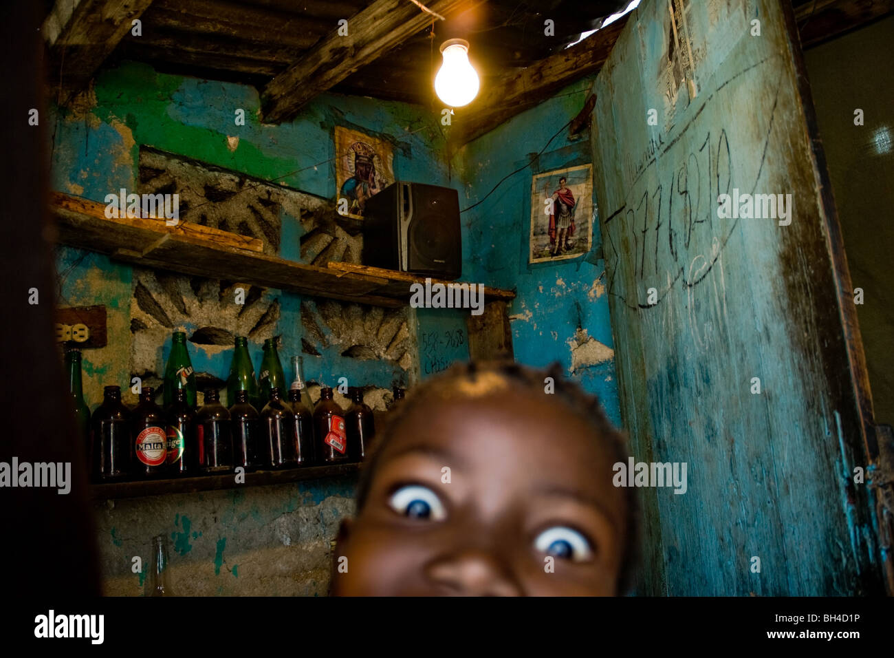 A Haitian boy trying to sell a bottle of soft drink inside the house in ...