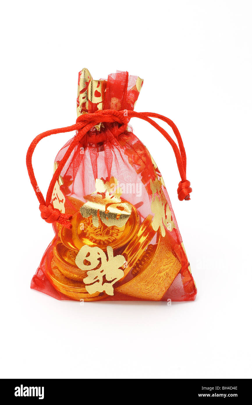 Chinese new year gold ingots and coins in red decorative sachet on ...